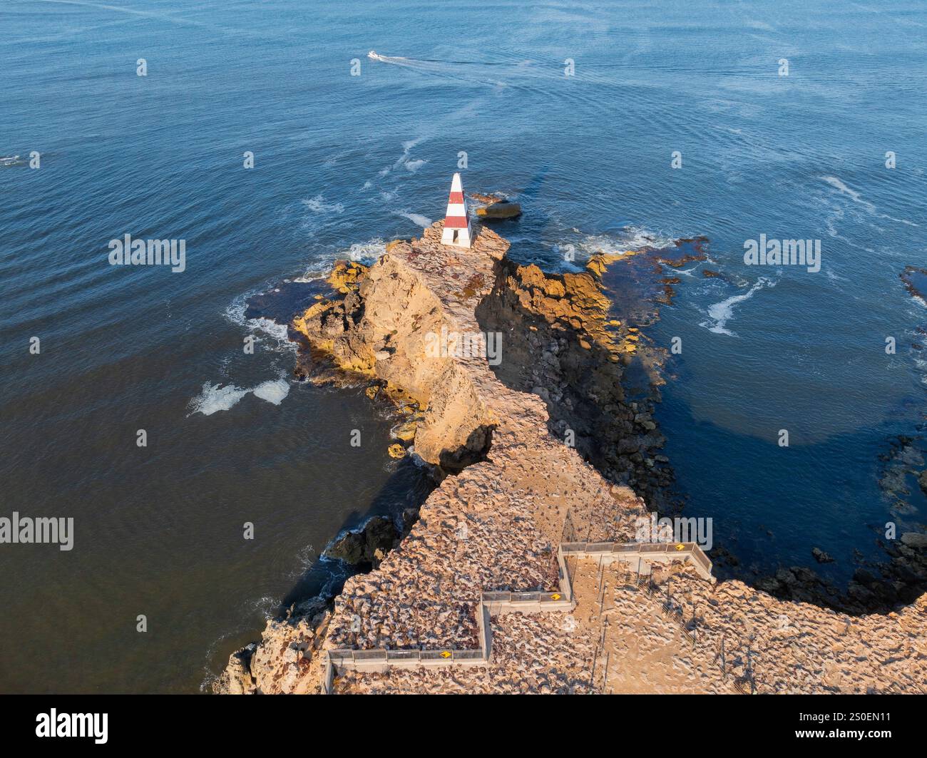 Aerial view of a beacon ona rocky point off a rugged coastline at Robe ...