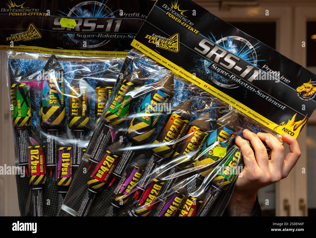 27 December 2024, Berlin: An employee of the fireworks store holds two ...