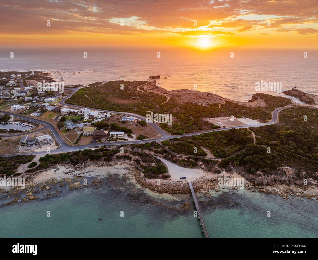 Aerial view of a coastal town and surrounding coastaline at sunset at ...