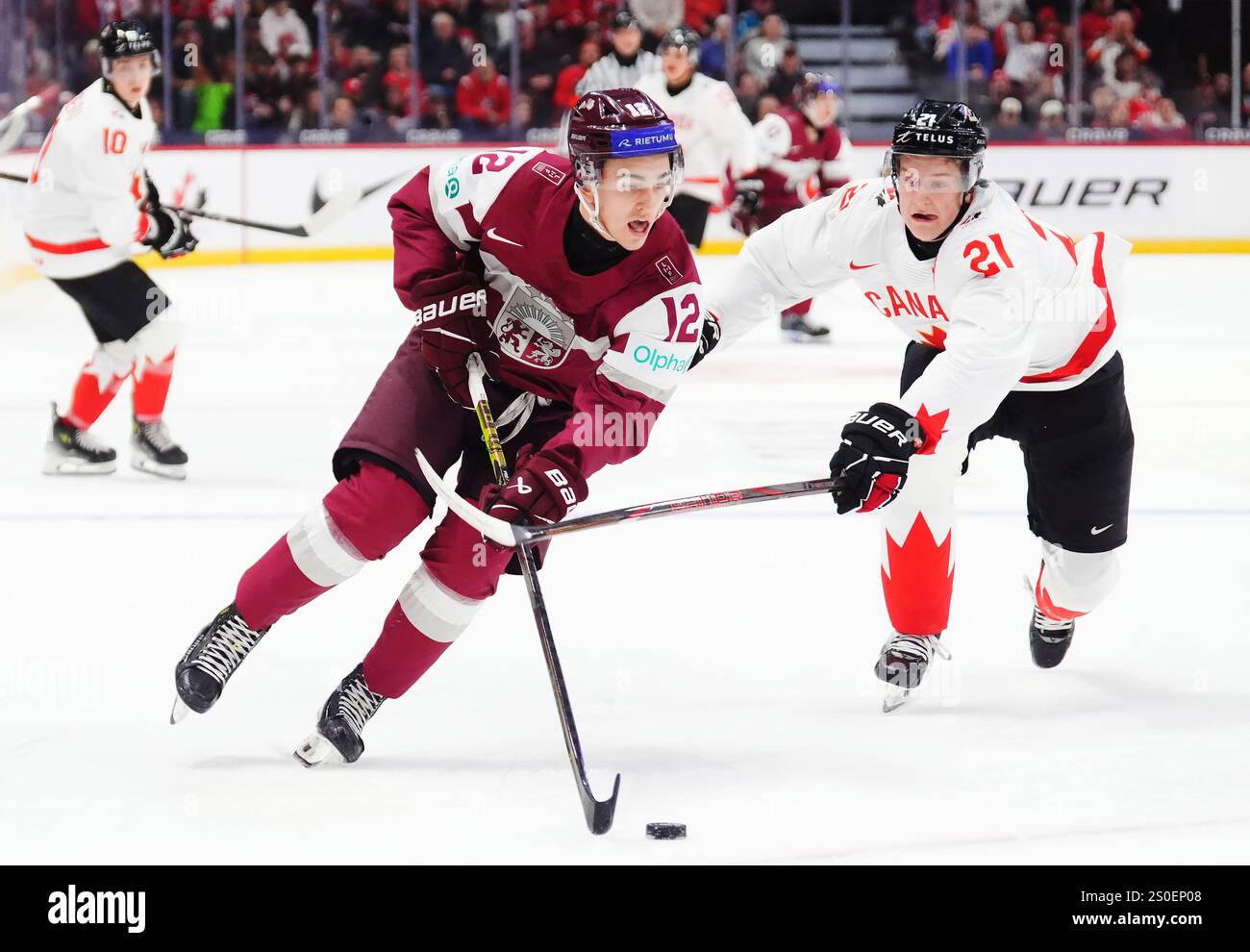 Ottawa, Canada. 27th Dec, 2024. Latvia's Toms Mots (12) protects the ...