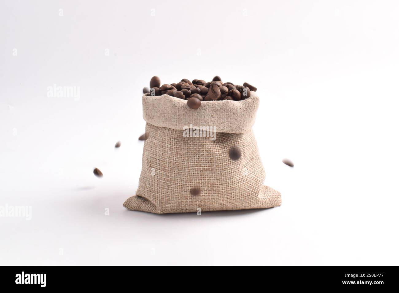 Roasted Coffee beans falling into the sack isolated on white background ...