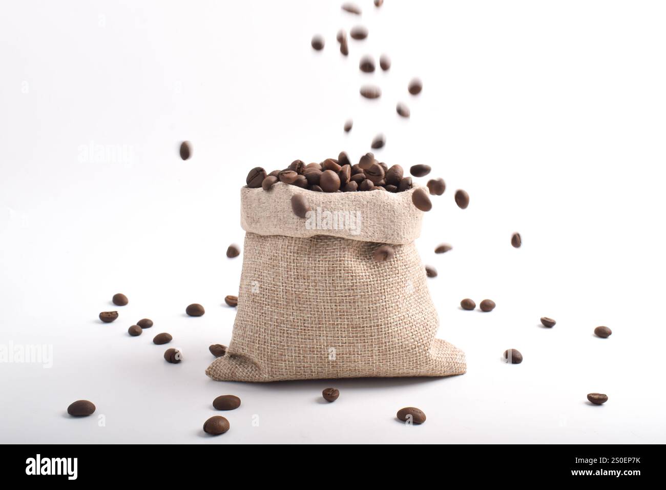 Roasted Coffee beans falling into the sack isolated on white background ...