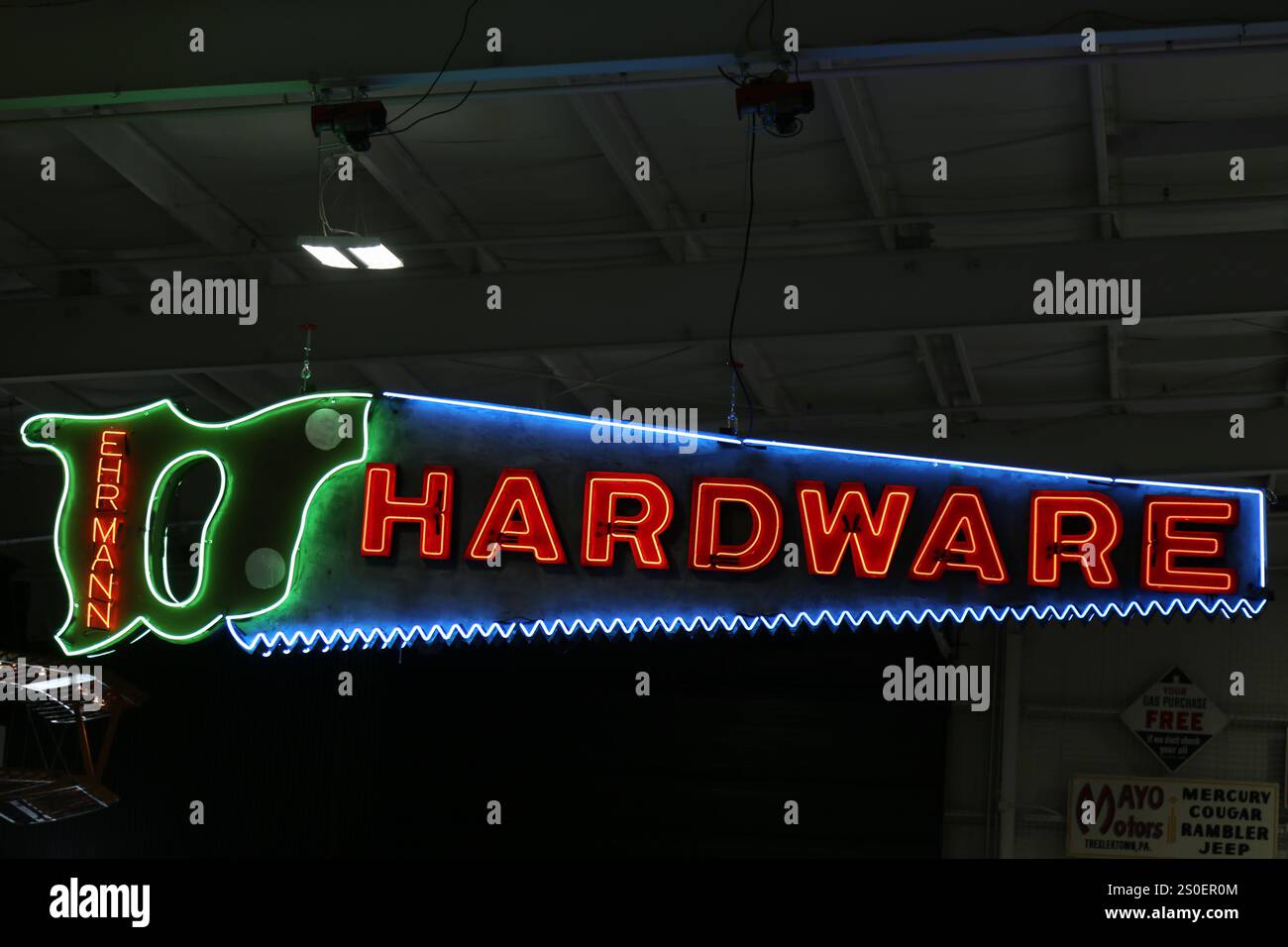 An illuminated neon Ehrmann Hardware sign in the shape of a handsaw on ...