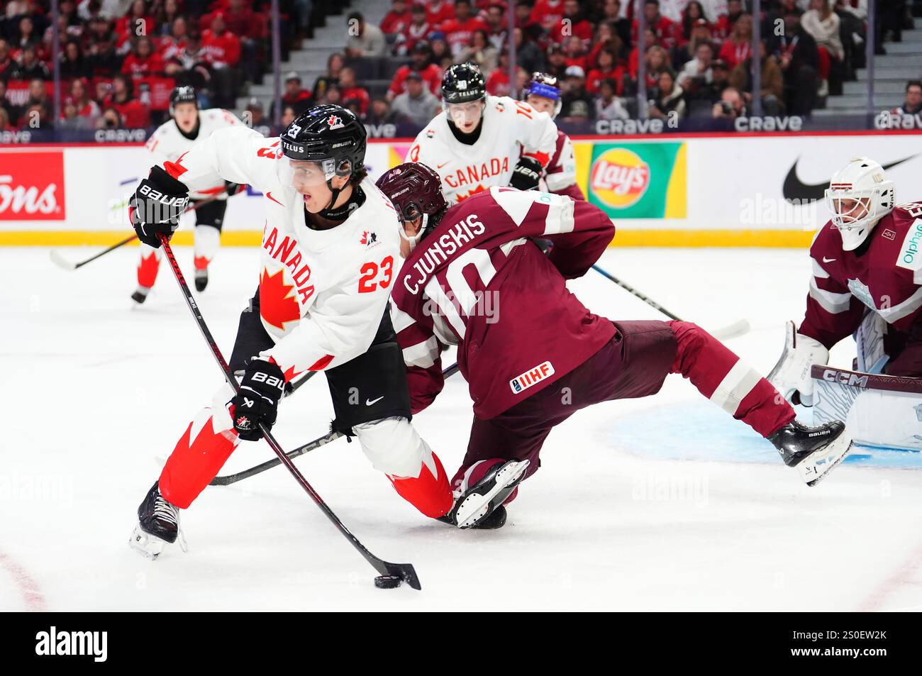 Canada's Tanner Howe (23) looks to pass the puck as Latvia's Harijs ...