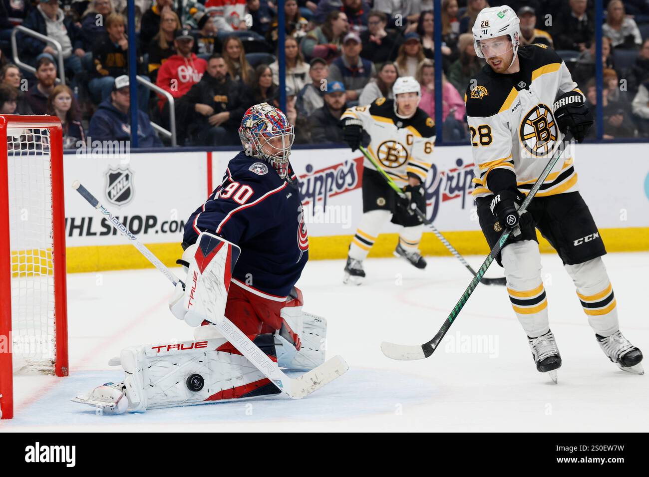 Columbus Blue Jackets' Elvis Merzlikins, left, makes a save against ...