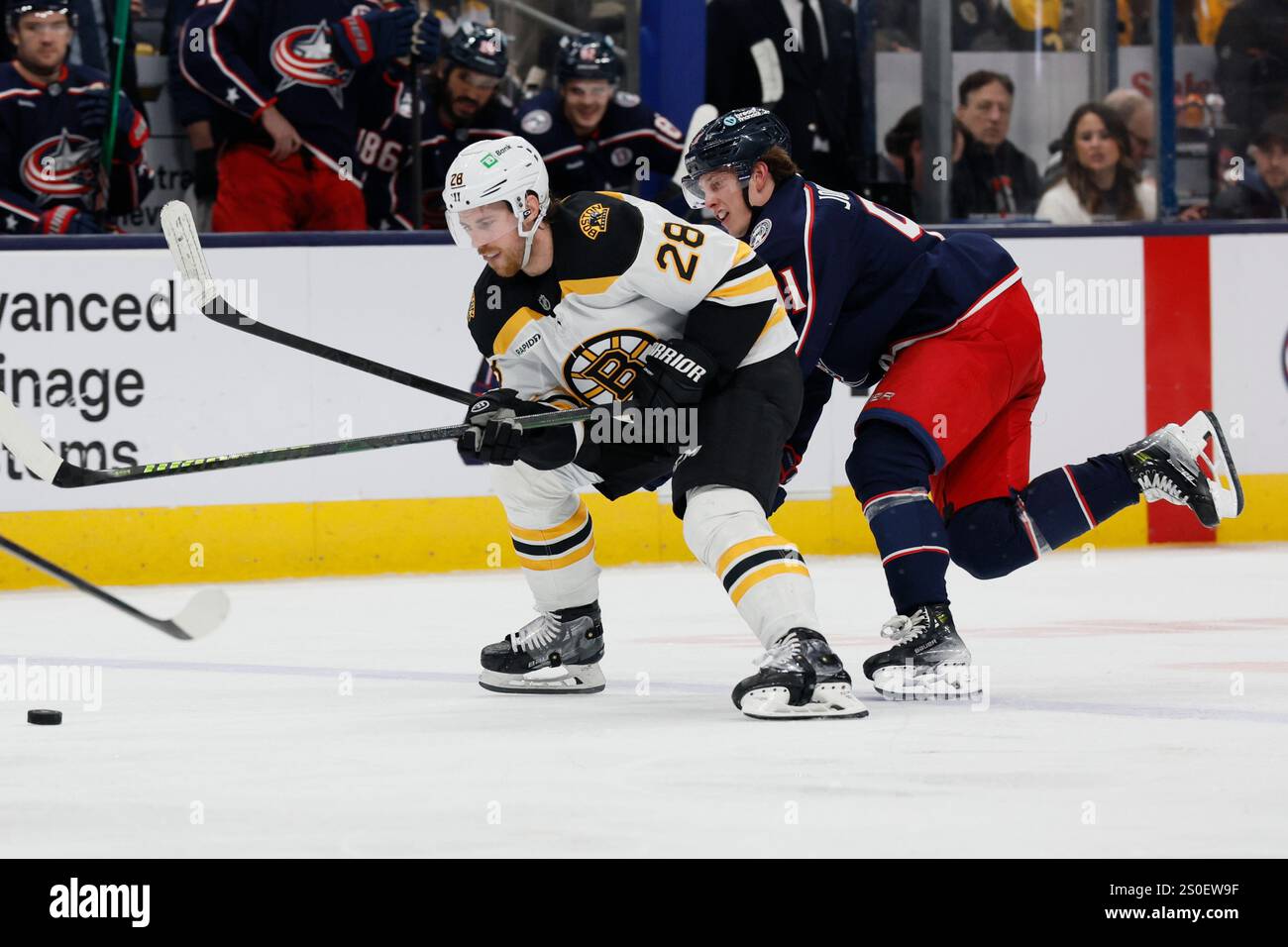 Boston Bruins' Elias Lindholm, left, skates past Columbus Blue Jackets ...