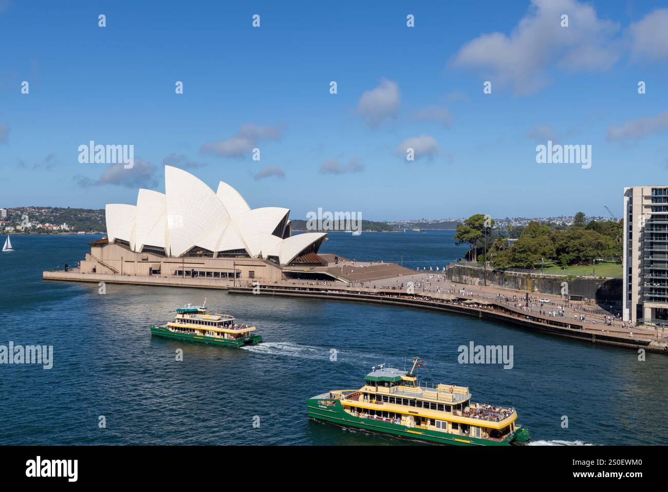 Sydney ferries pass the Sydney Opera House at Bennelong point ...