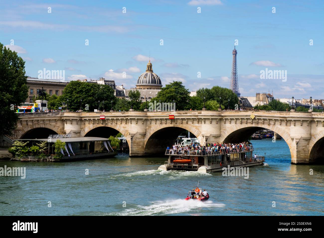 Tour boat passing under the Pont Neuf Bridge over the Seine with the ...
