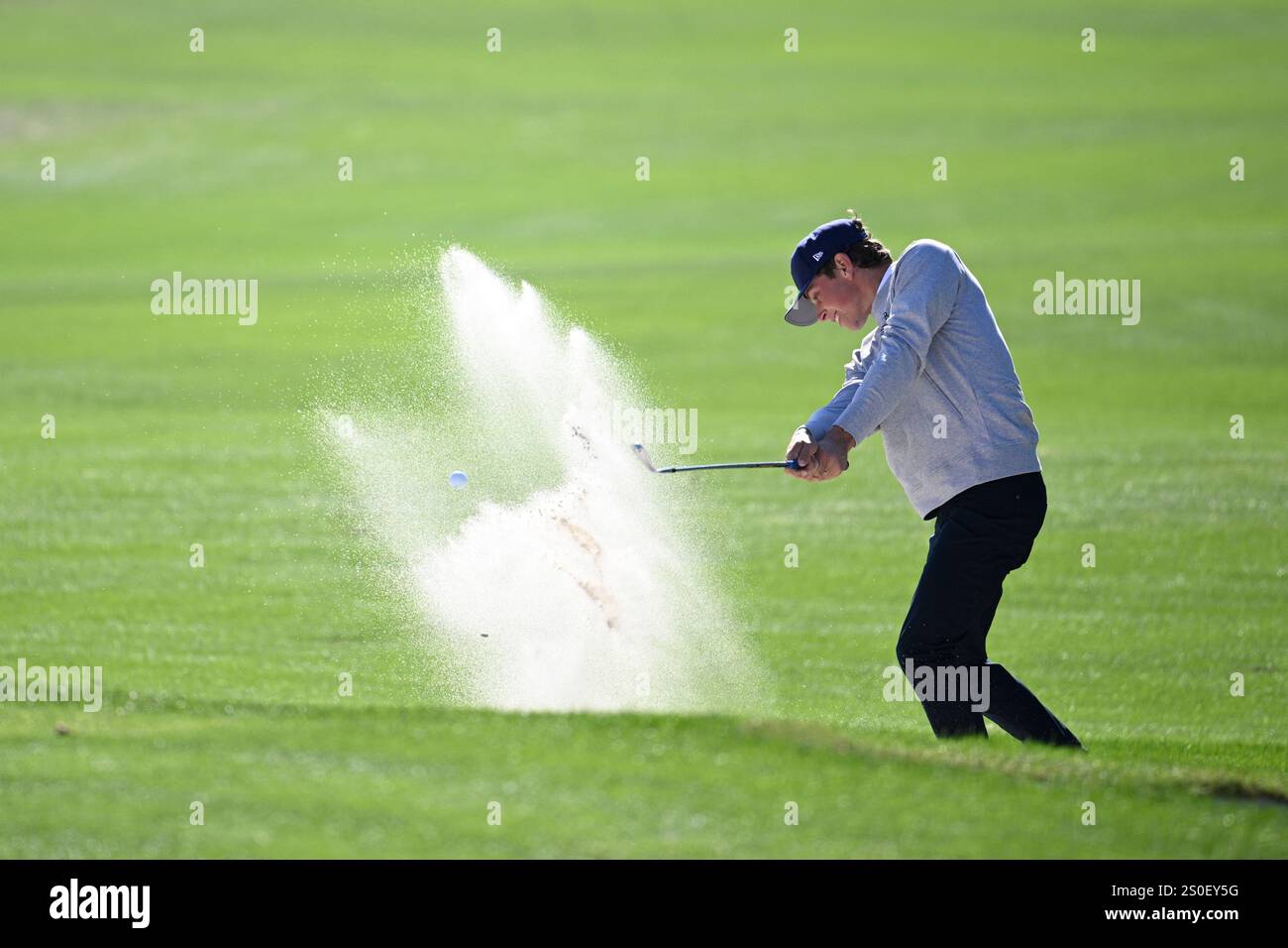 Luke Leonard hits out of a bunker onto the third green during the first ...