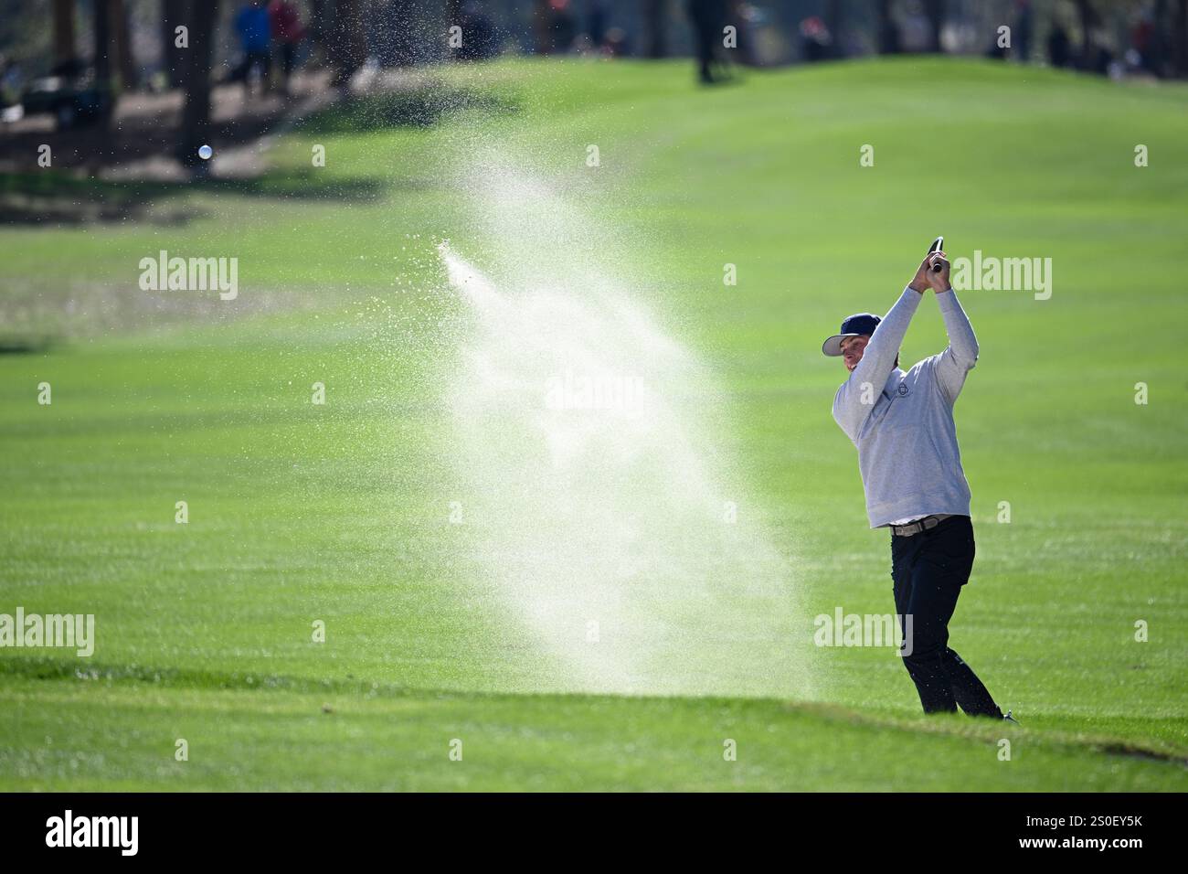 Luke Leonard hits out of a bunker onto the third green during the first ...