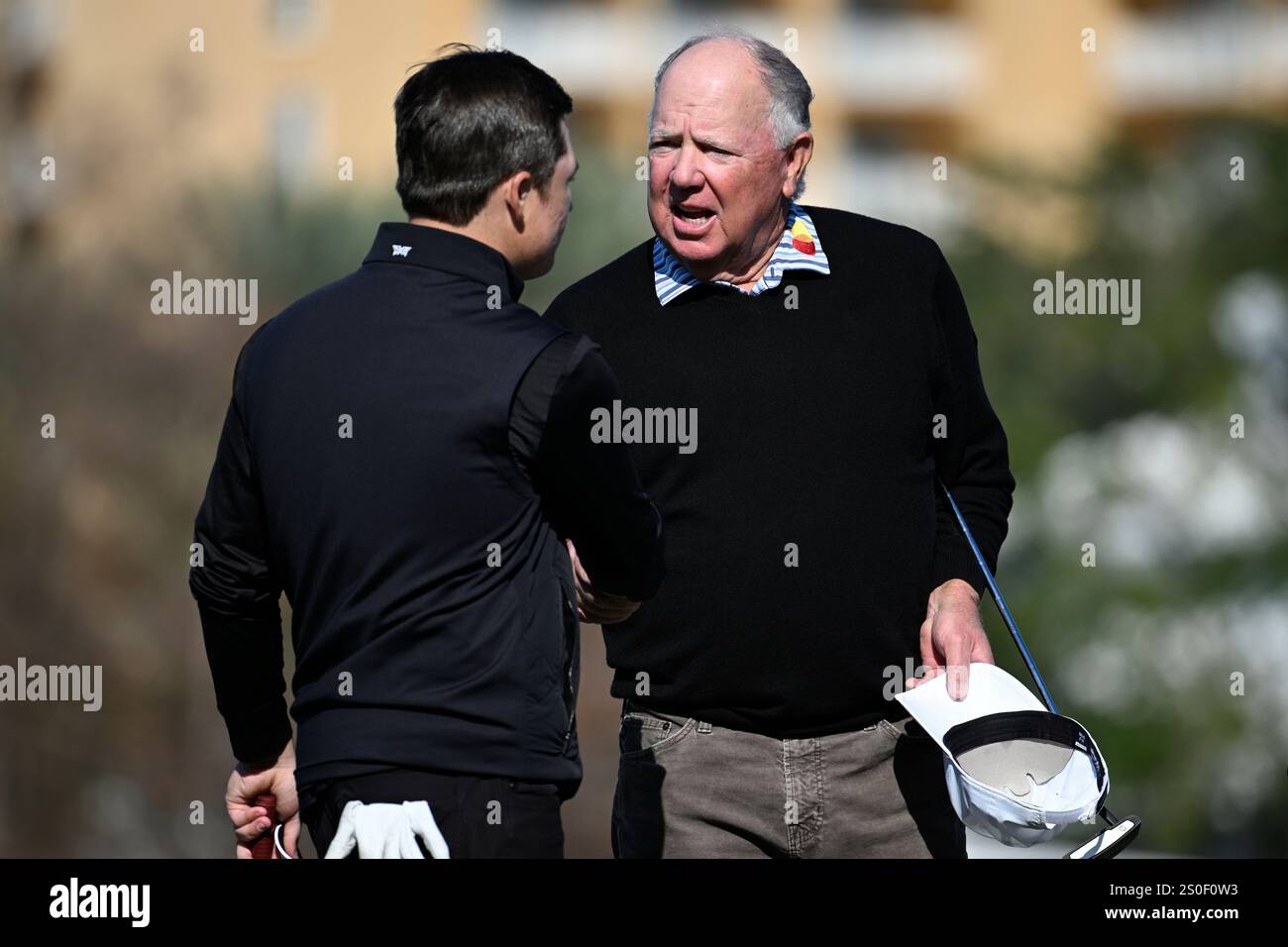 Mark O'Meara, right, shakes hands with Alexander Hall, grandson of Gary ...
