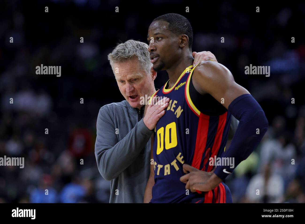 Golden State Warriors head coach Steve Kerr, left, speaks with forward Jonathan Kuminga during ...