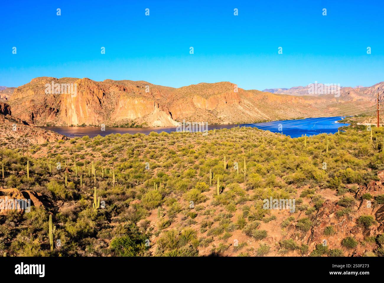 A desert landscape with a river running through it. The sky is clear ...