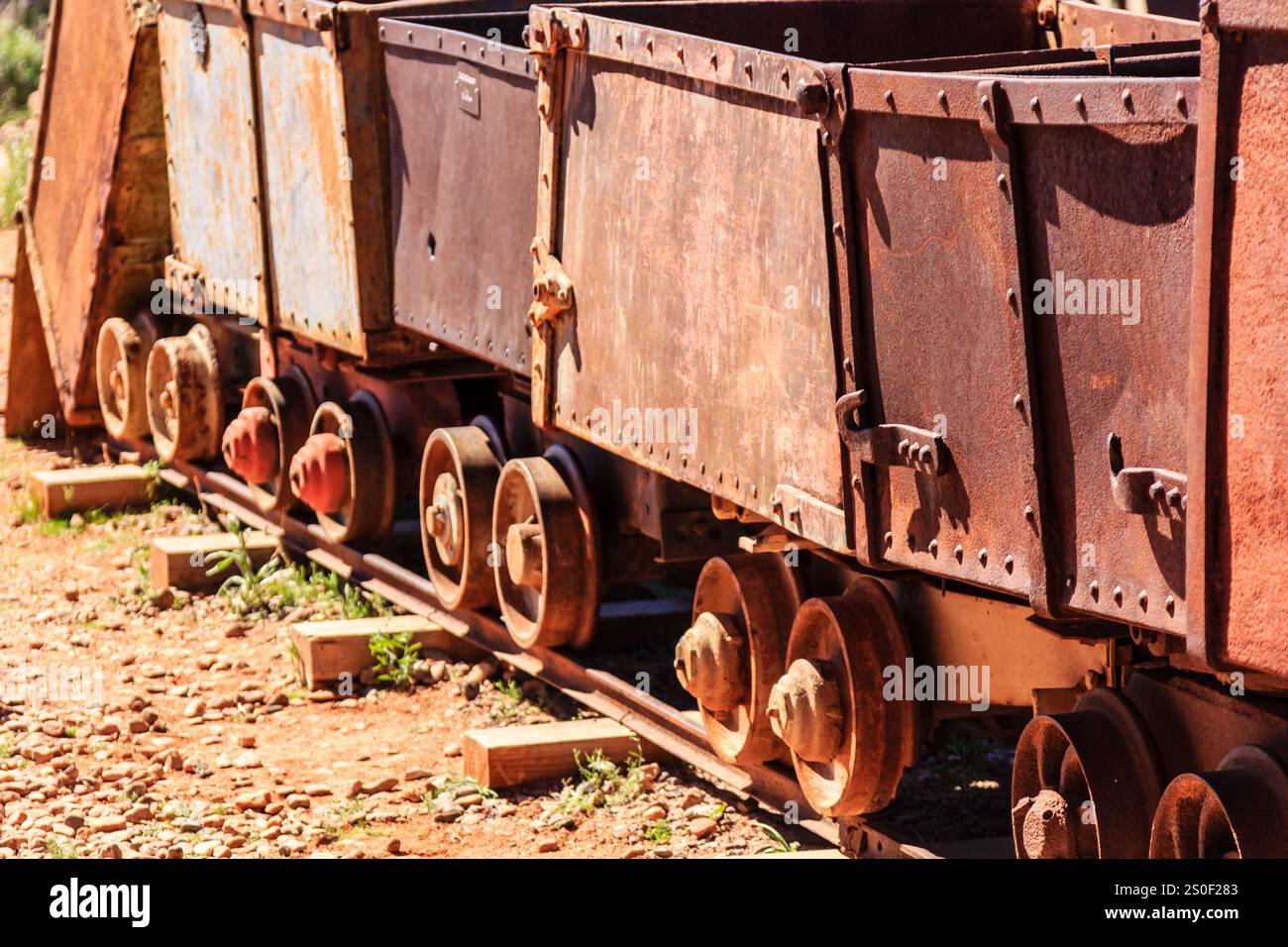 A train with old rusty wheels and a rusted caboose. The train is parked ...