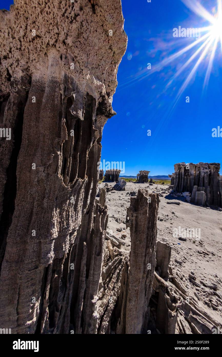 A rocky cliff with a blue sky in the background. The sun is shining ...