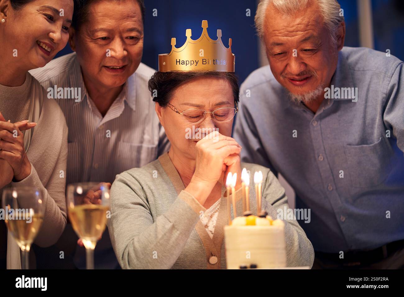 happy senior asian woman celebrating birthday with group of old friends ...