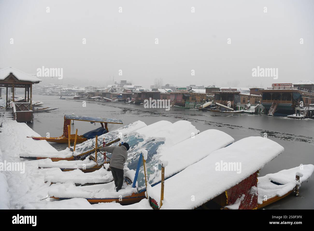 Srinagar, Jammu And Kashmir, India. 28th Dec, 2024. A boatman clears ...