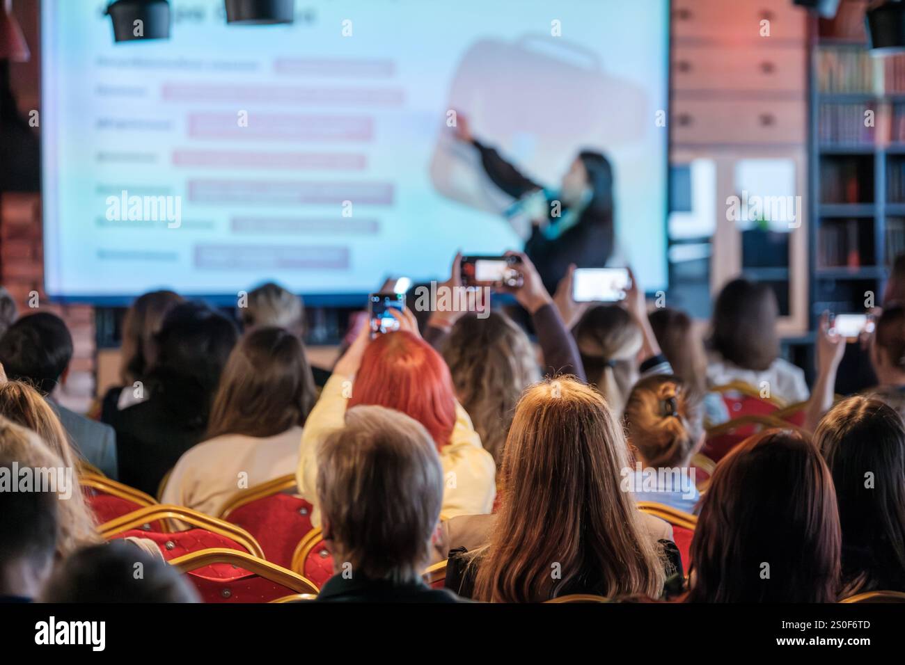 Audience captures moments of a presentation given by a speaker on a ...