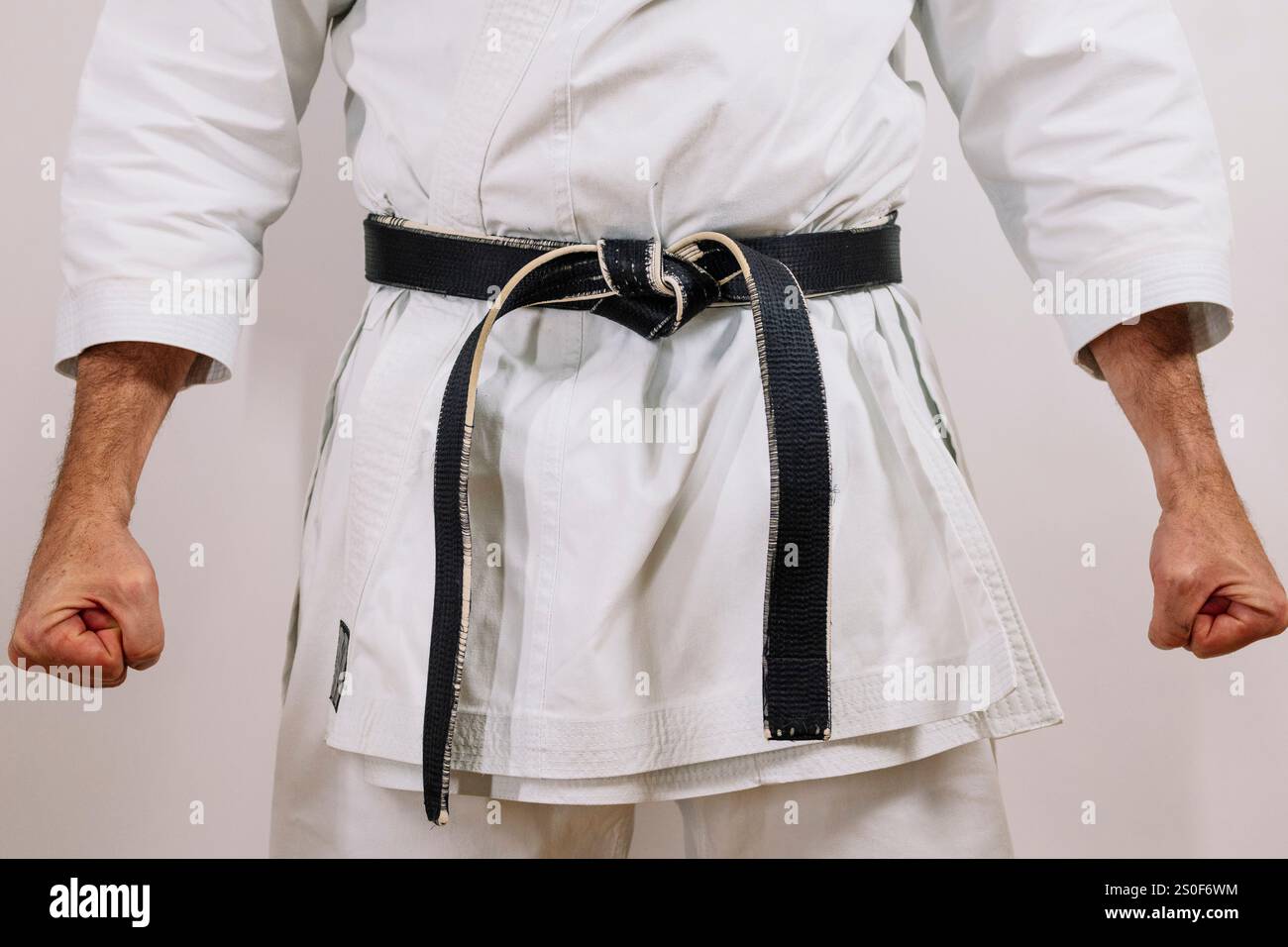Black belt tied around a white gi Stock Photo - Alamy