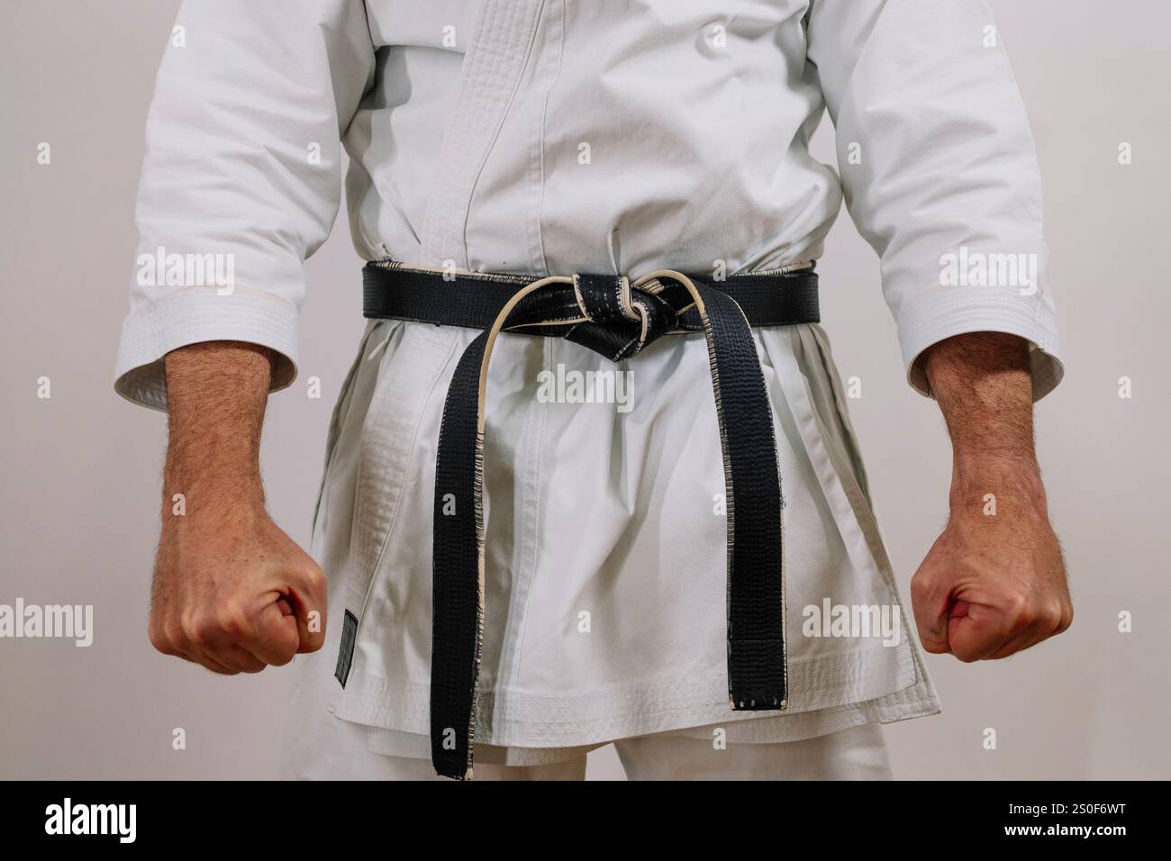 Black belt tied around a white gi Stock Photo - Alamy