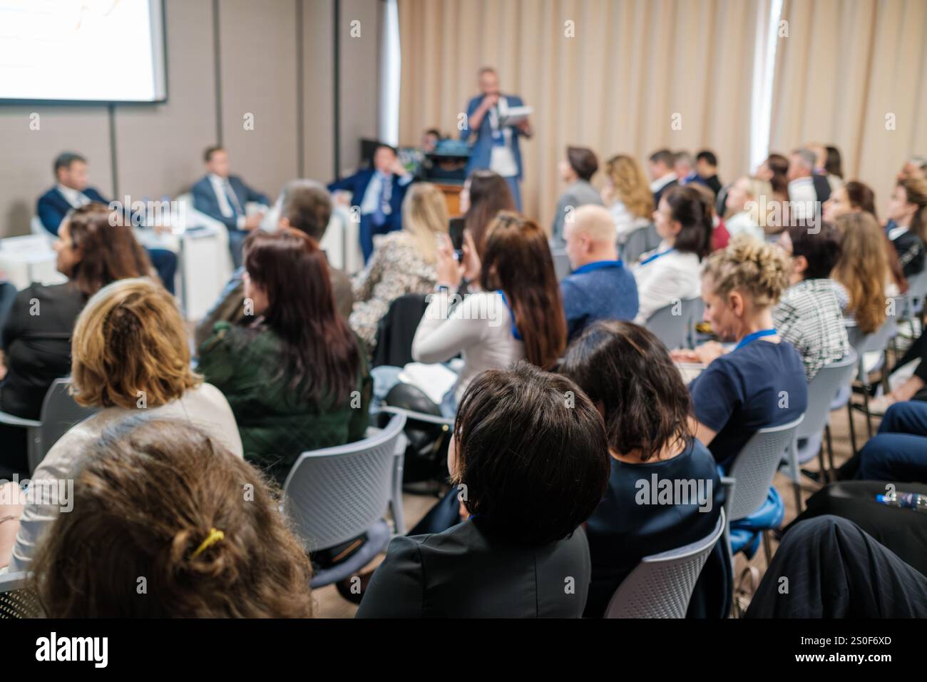 Audience attending a professional seminar with a speaker conducting ...