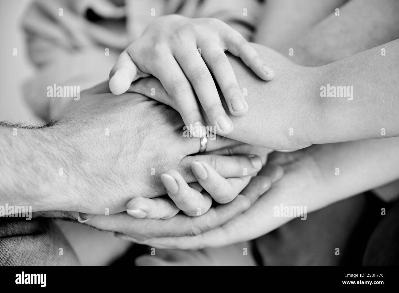 Cute family putting stacked hands together promising help and support ...