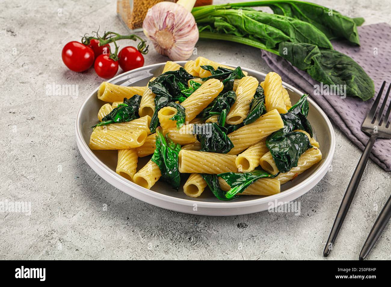 Italian cuisine - pasta tortiglioni with spinach Stock Photo - Alamy