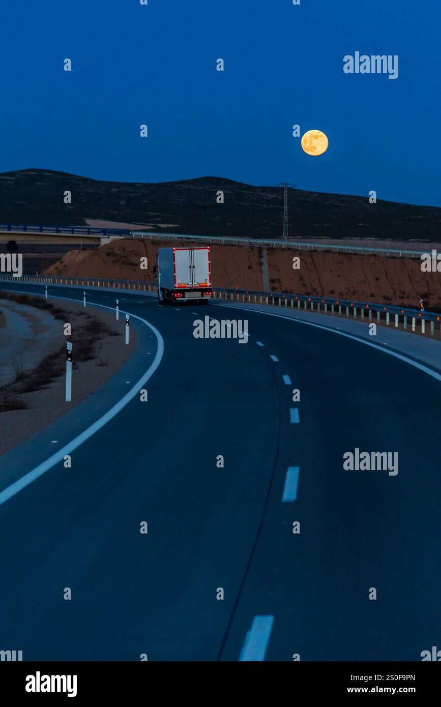 Truck with a refrigerated semi-trailer driving at dusk on a highway ...