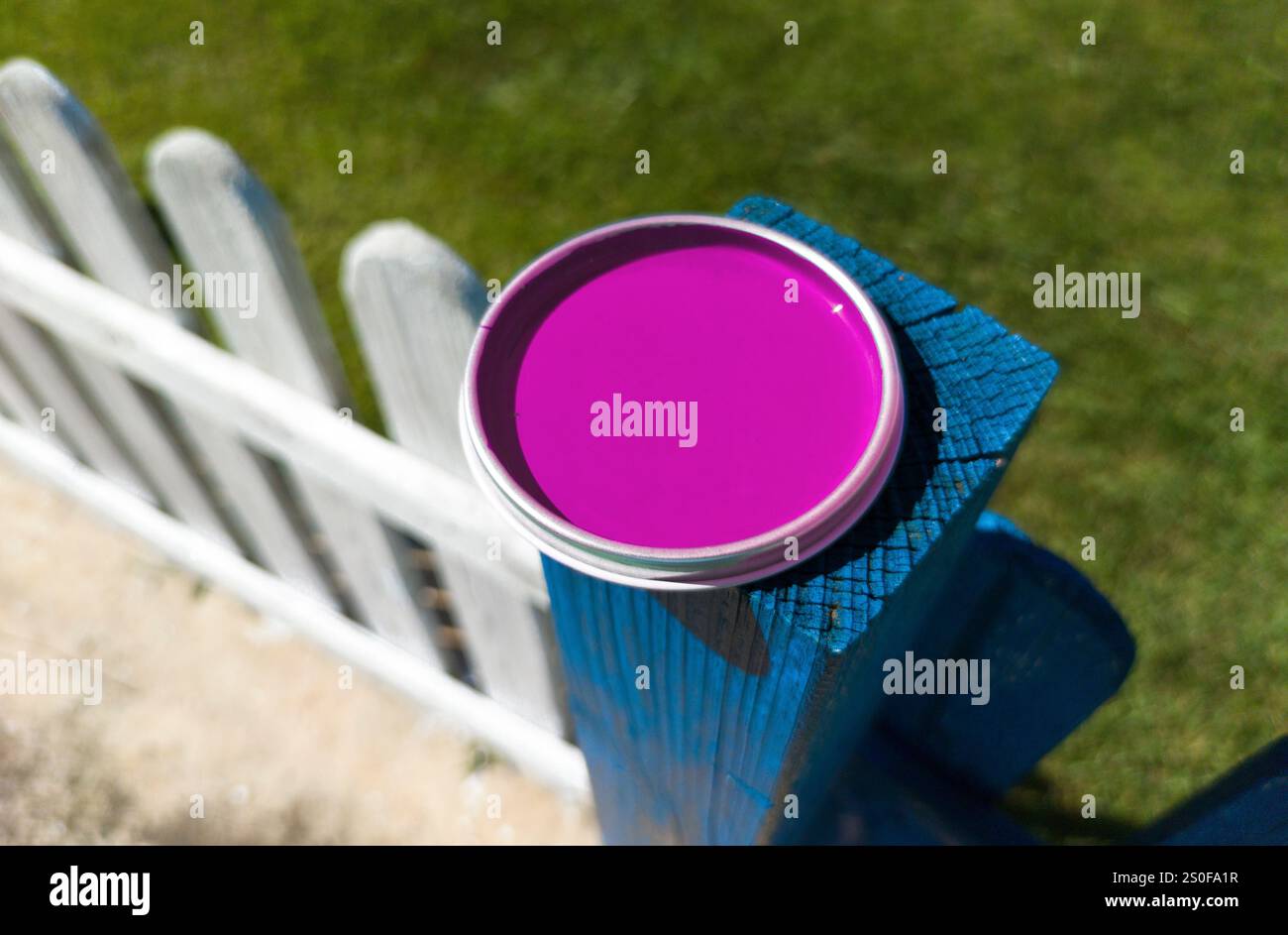 Pink can lid resting over fence pole. Painting a wooden fence with ...