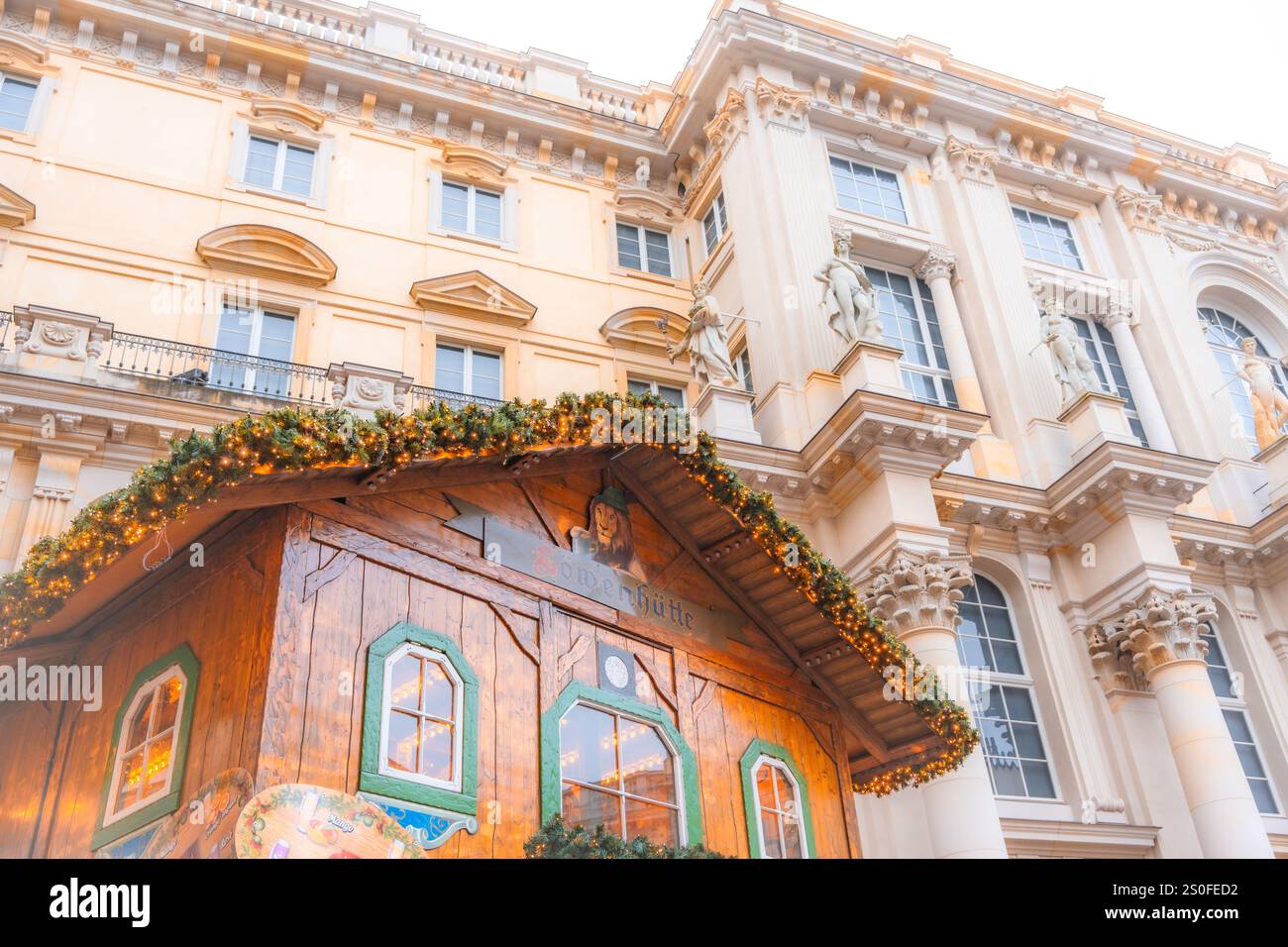 A small wooden hut with a green roof is covered in Christmas ...