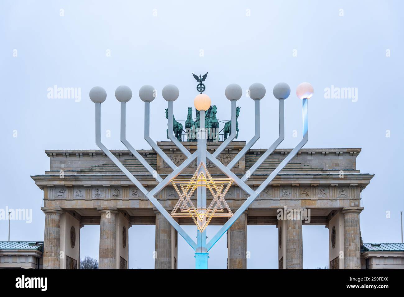In front of the building stands a large, ornate, illuminated menorah in ...