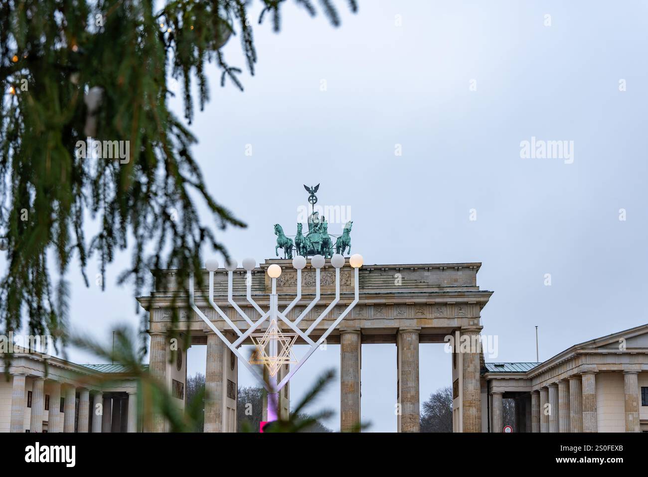 A large, ornate, lit up menorah is displayed in front of a building ...
