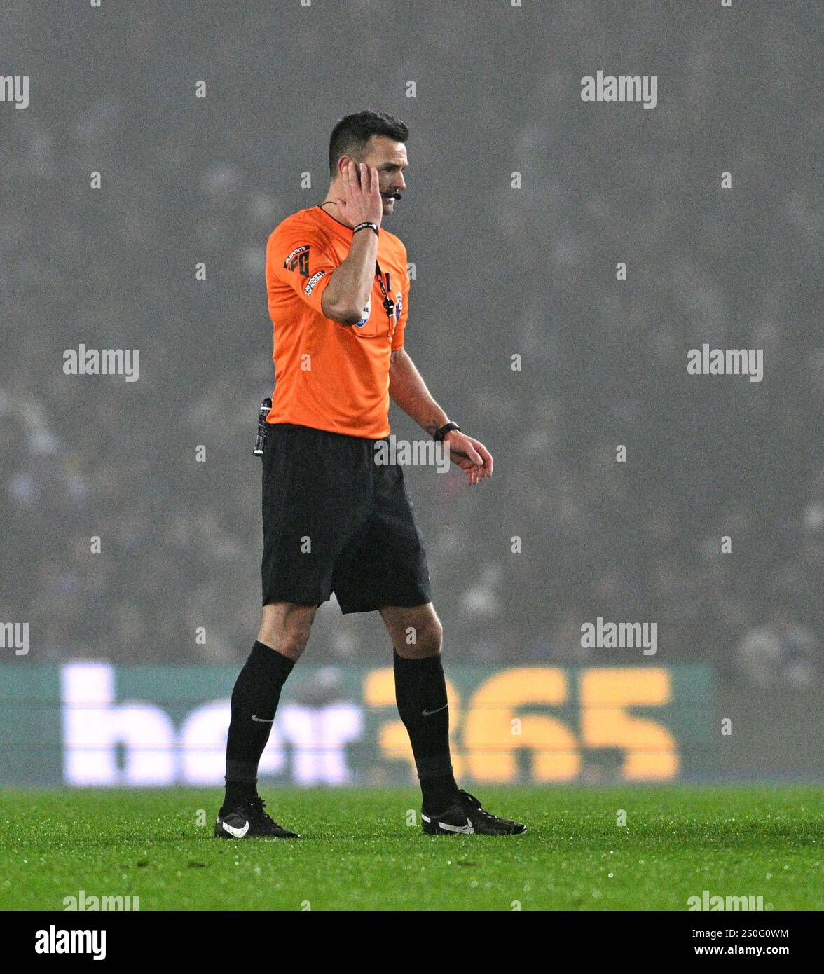 Referee Andrew Madley checks his earpiece for a VAR check during the ...