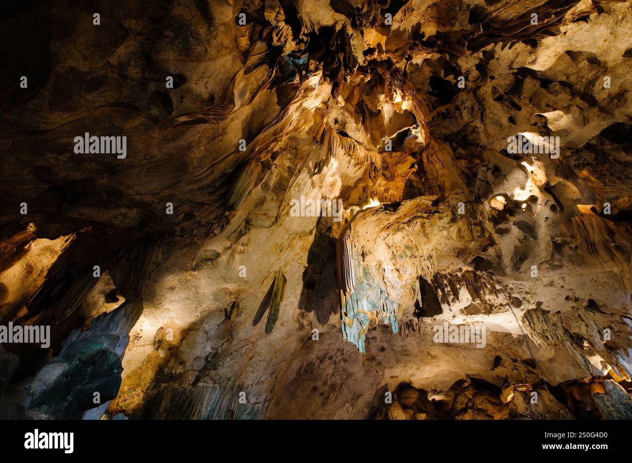 a cave with stalagmites and stalactites. The cave is large and dark ...