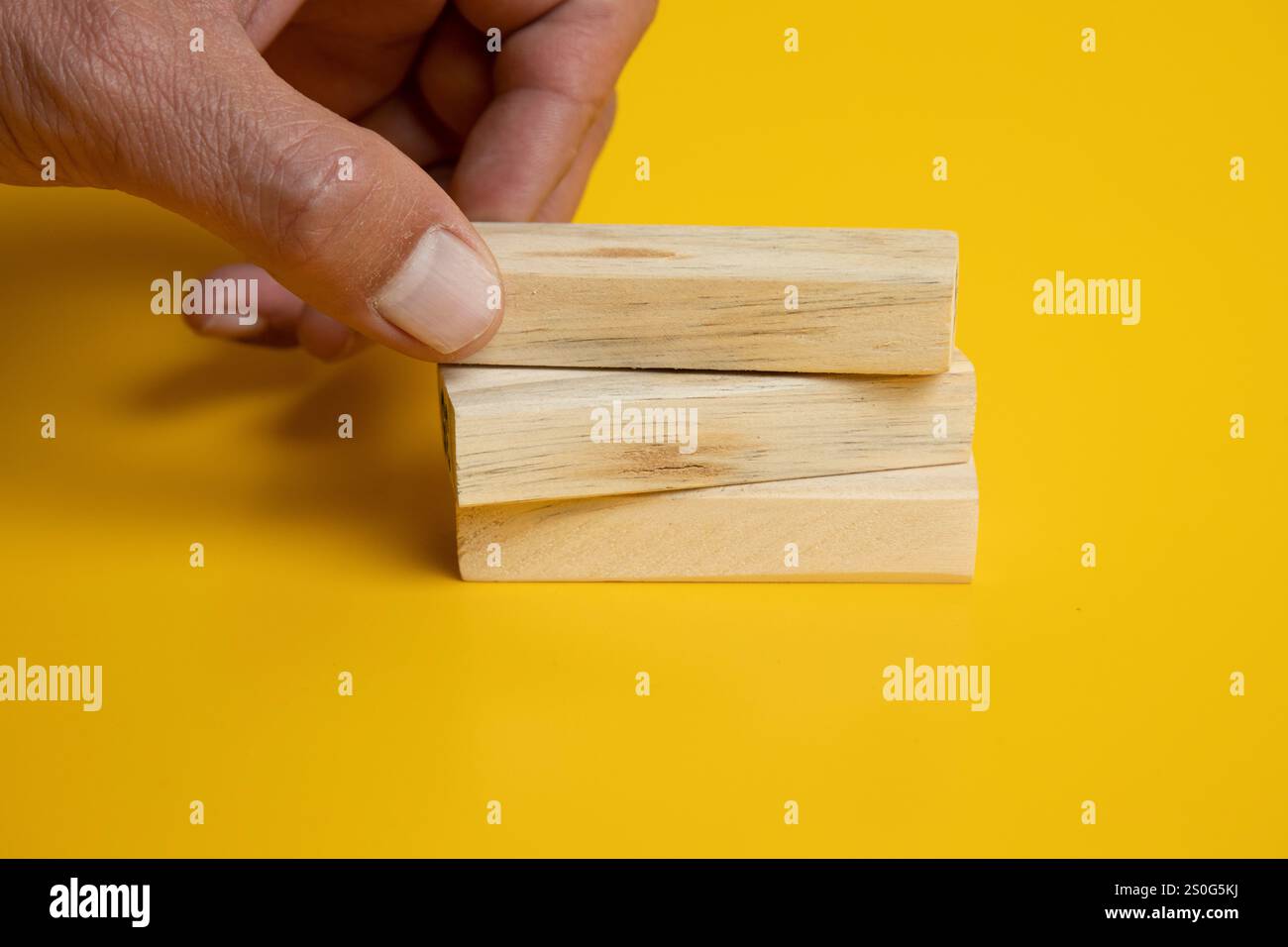 An image featuring three wooden Jenga blocks arranged neatly on a solid ...
