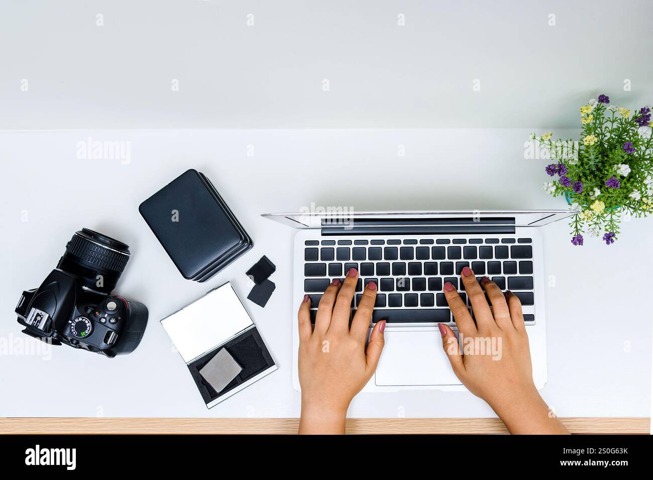 hands put on keyboards of laptop with digital camera and storage on ...