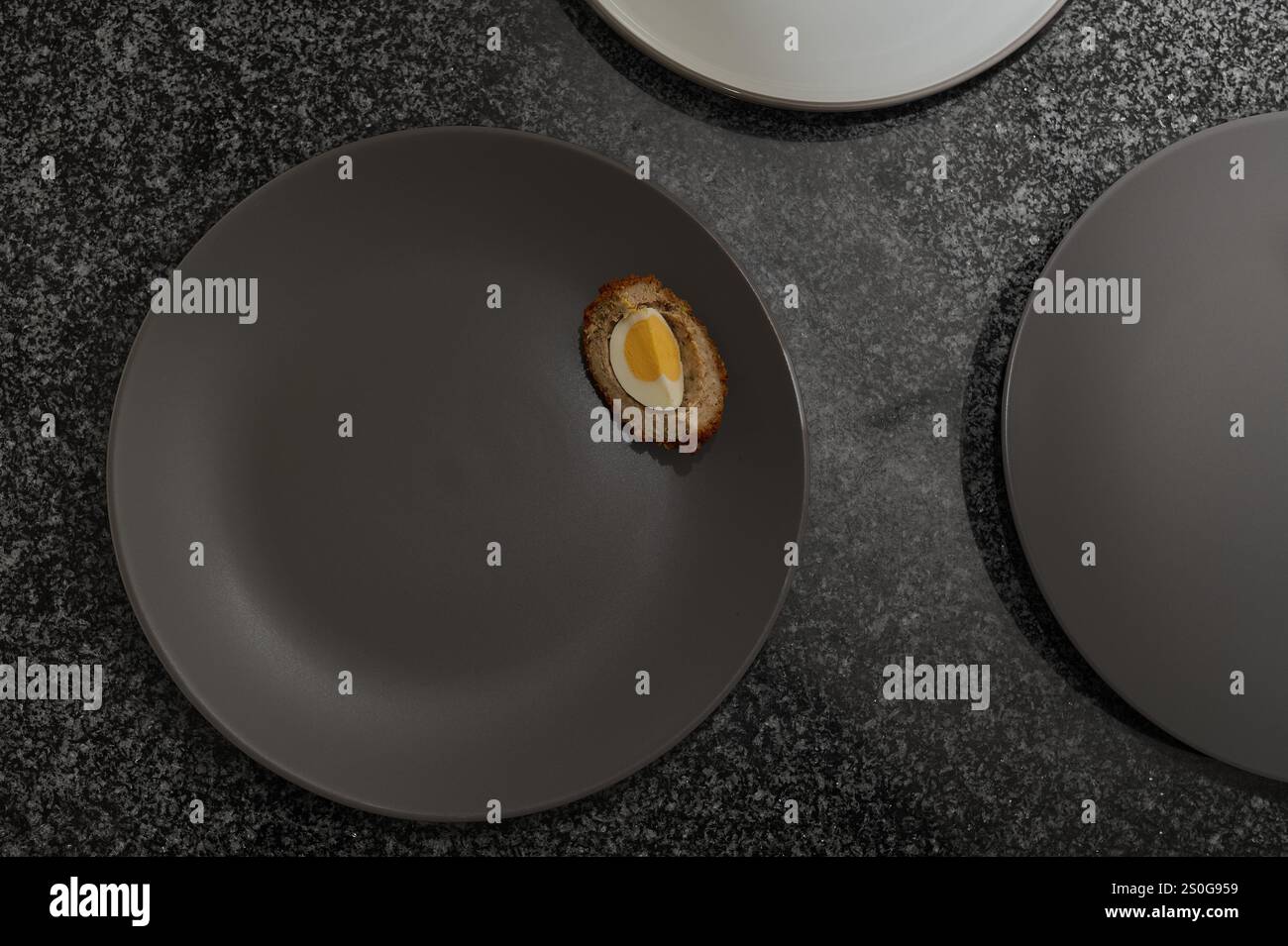 top down aerial view of a Quarter of a scotch egg on a grey stone ...