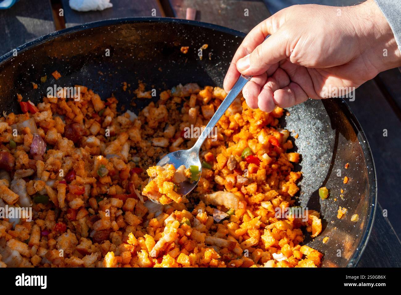 Preparing La Mancha or Castilian migas as a family where everyone eats ...