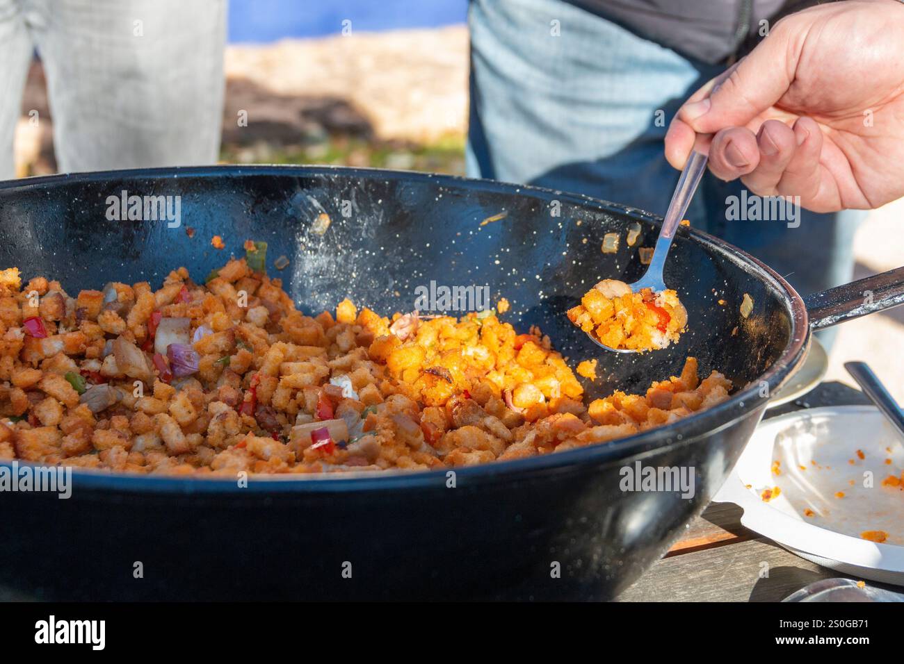 Preparing La Mancha or Castilian migas as a family where everyone eats ...