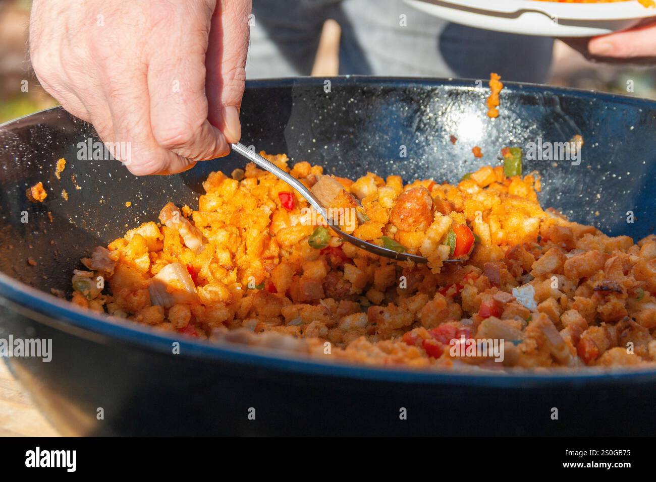 Preparing La Mancha or Castilian migas as a family where everyone eats ...