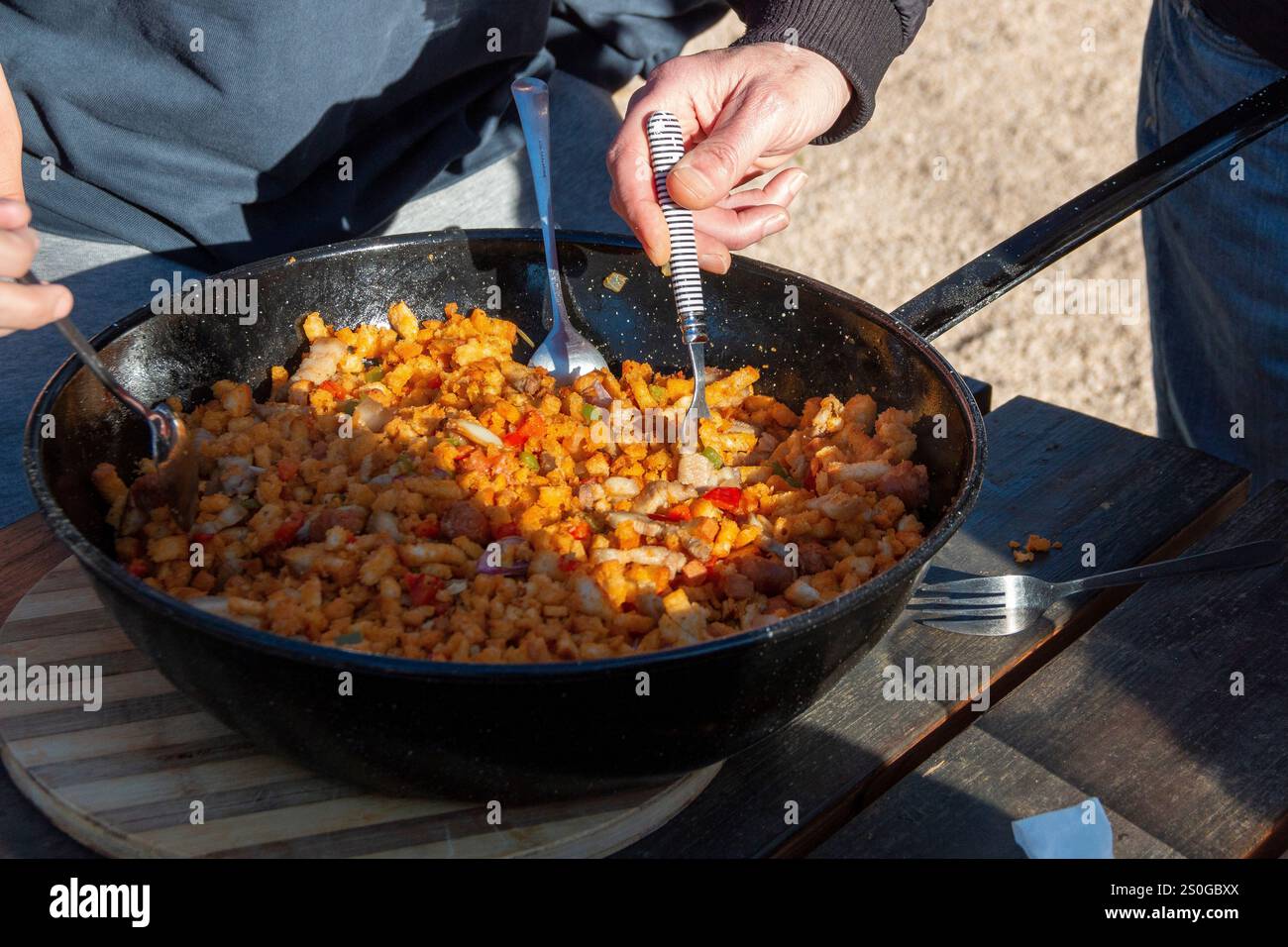 Preparing La Mancha or Castilian migas as a family where everyone eats ...