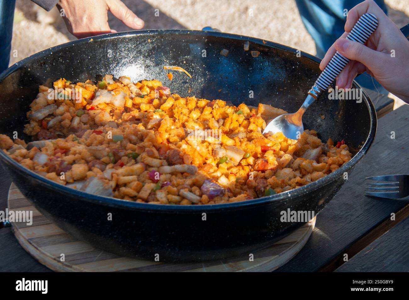 Preparing La Mancha or Castilian migas as a family where everyone eats ...