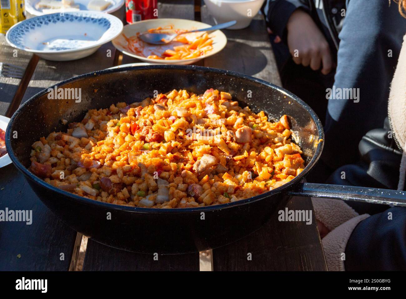 Preparing La Mancha or Castilian migas as a family where everyone eats ...