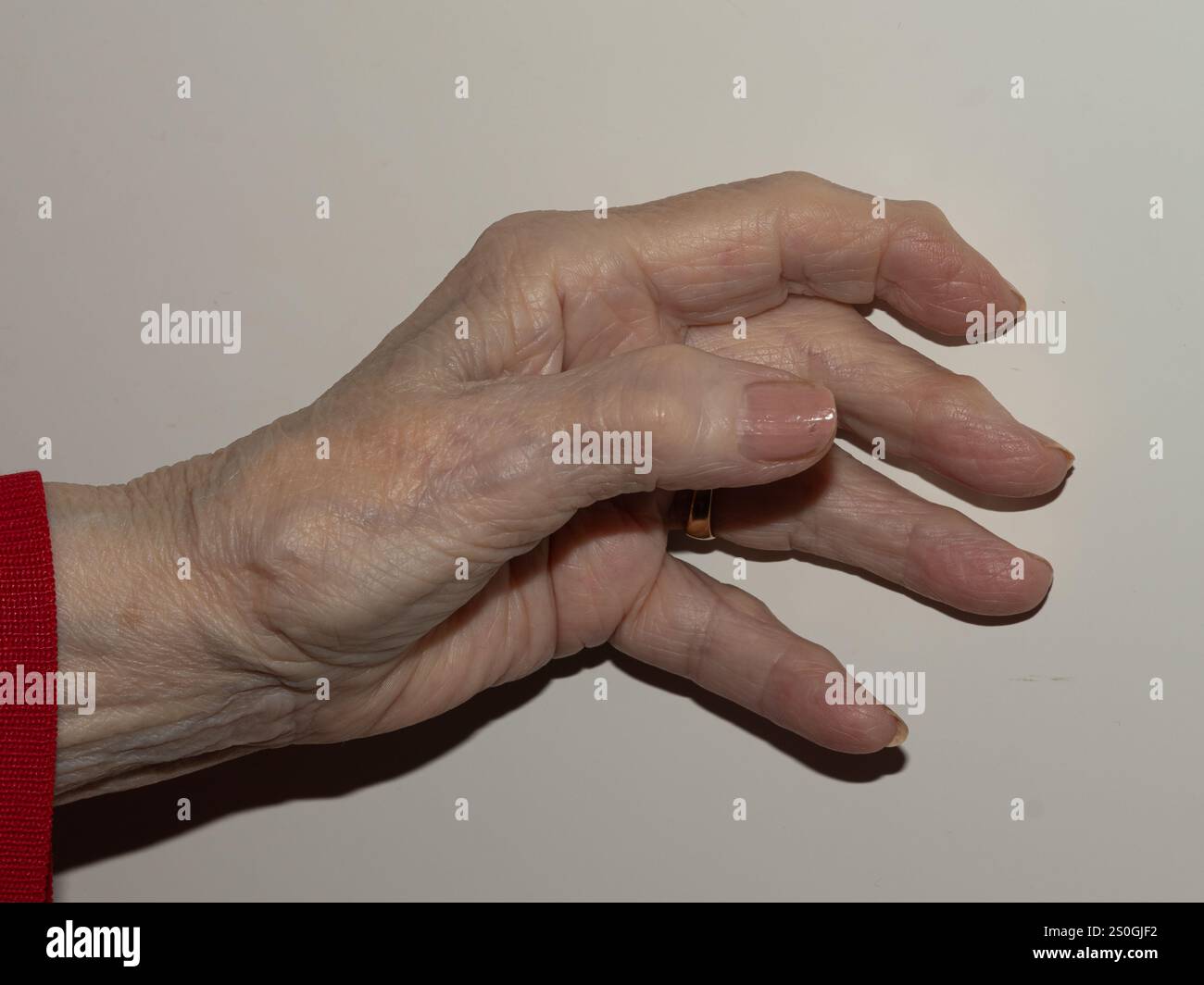 A serene close-up of an elderly hand resting, highlighted by a gold ...
