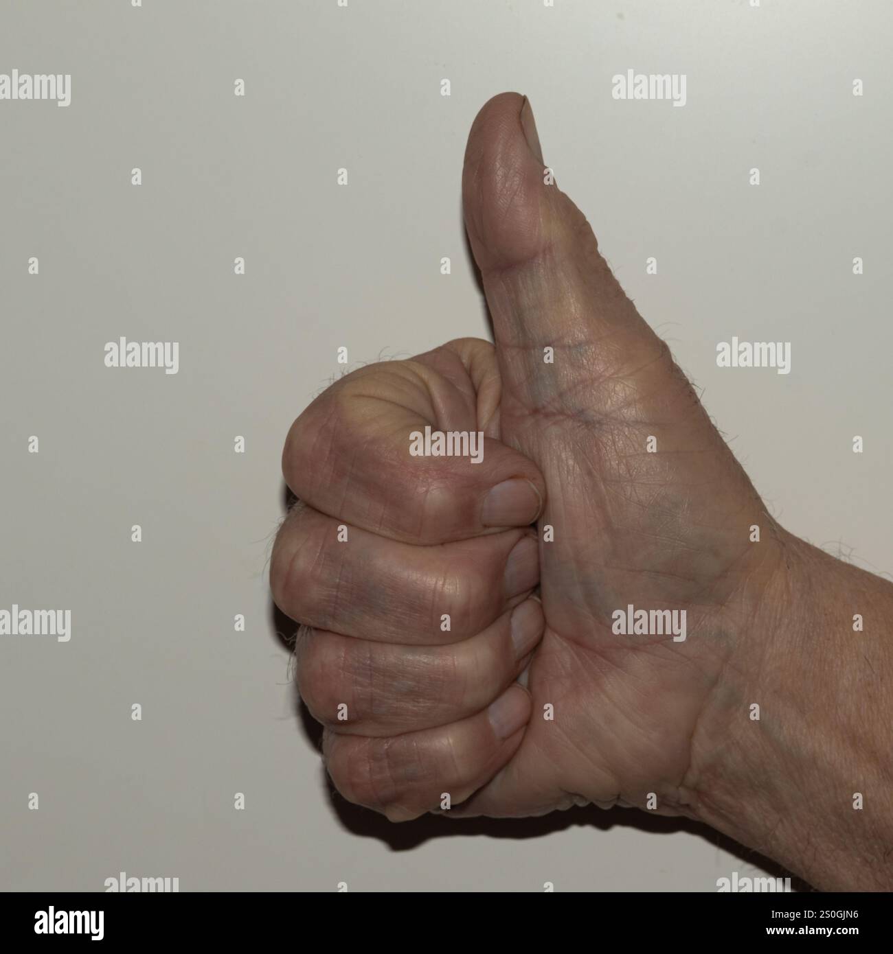 Close-up image of an aged hand giving a thumbs up, showing detailed ...