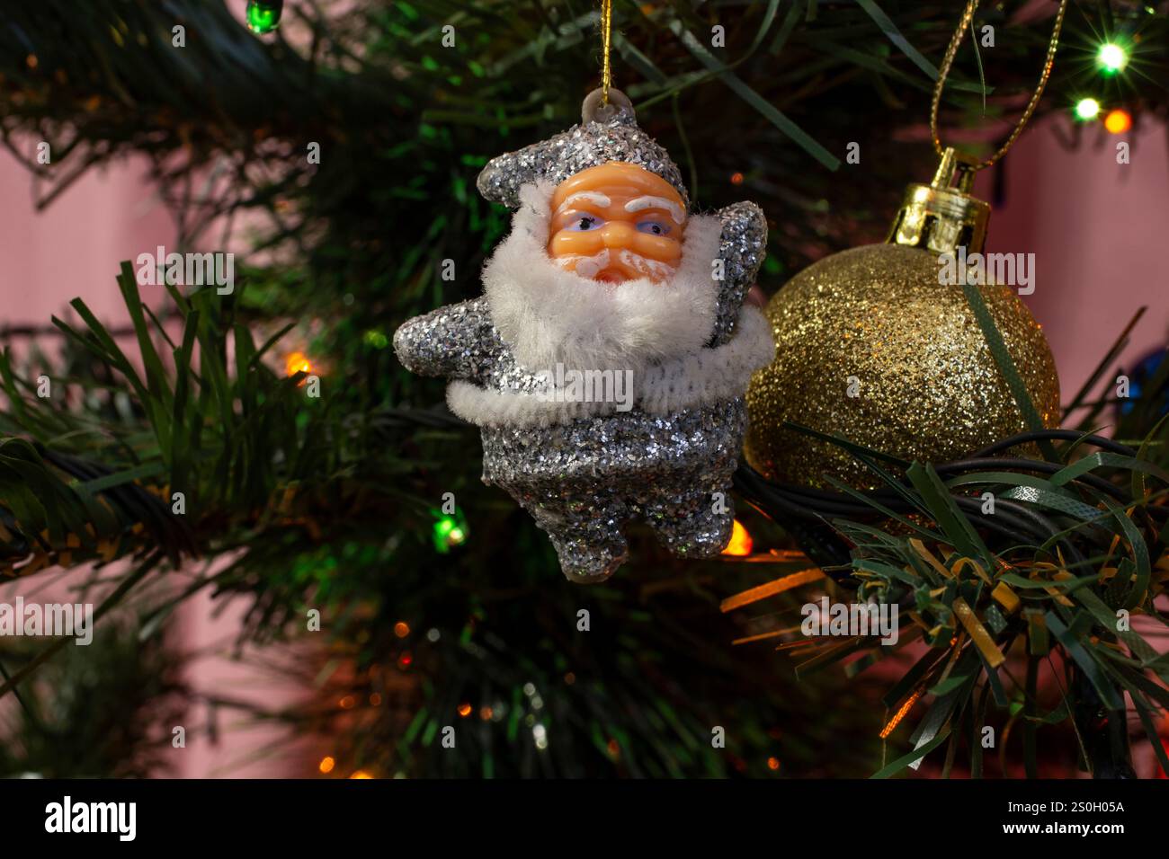Small silver santa klaus bauble in a plastic tree with christmas lights ...