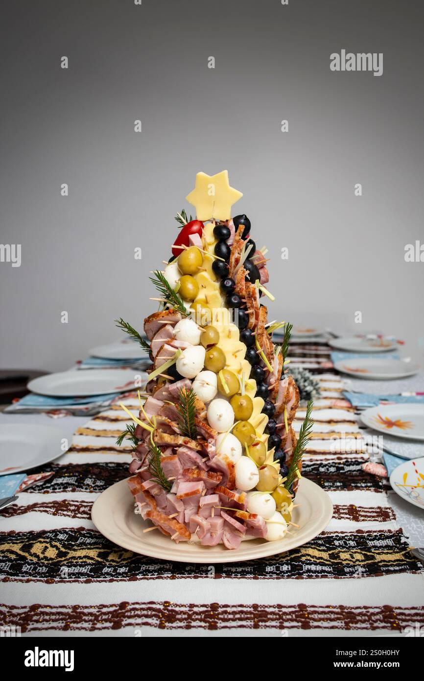 Appetizer arranged in the shape of a christmas tree, salami, ham ...