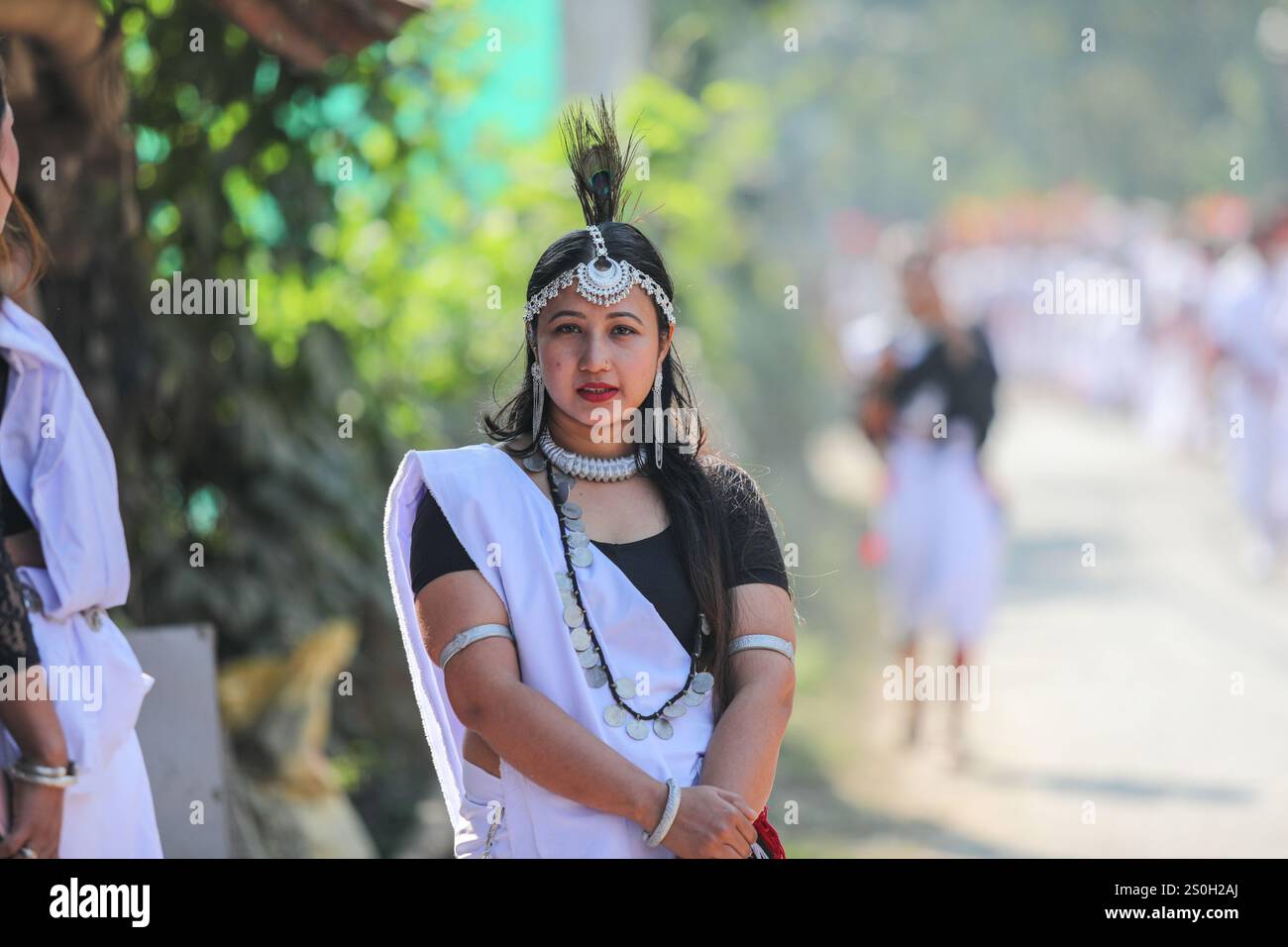 Chitwan, Nepal. 26th Dec, 2024. A Tharu woman poses wearing their traditional dress while taking ...