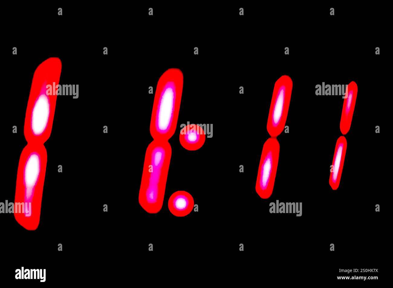 A digital clock face showing the time in red numbers on a black ...