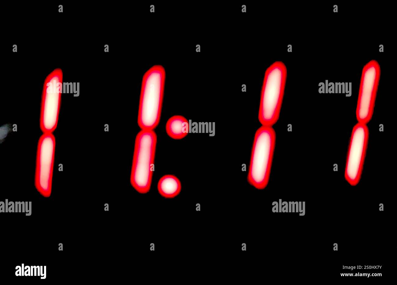 A digital clock face showing the time in red numbers on a black ...
